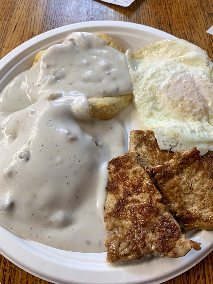 Tenderloin, eggs, and biscuits drowning gloriously in pepper gravy - the kind of breakfast that fuels small-town America.