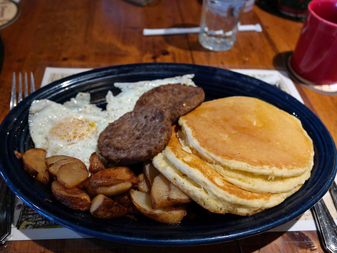 Breakfast that fuels mountain adventures. Those pancakes are so fluffy they could practically float off the plate if not anchored by that sausage.