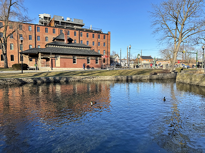 The former train station reflects in still waters, a brick testament to when rail was king and travelers' first glimpse of Lititz's welcoming embrace.