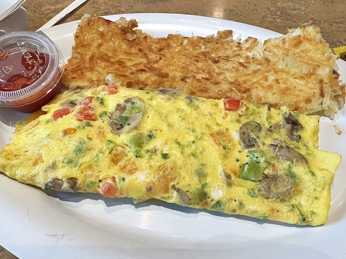 Breakfast of champions: a veggie omelet with hash browns that could convert a carnivore. Fluffy eggs meet colorful vegetables in perfect harmony.