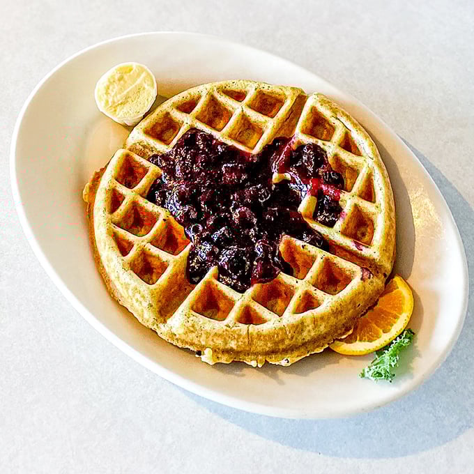 A golden waffle cradles warm blueberry compote like a hammock holds a napping cat &ndash; perfectly and with just the right amount of give.