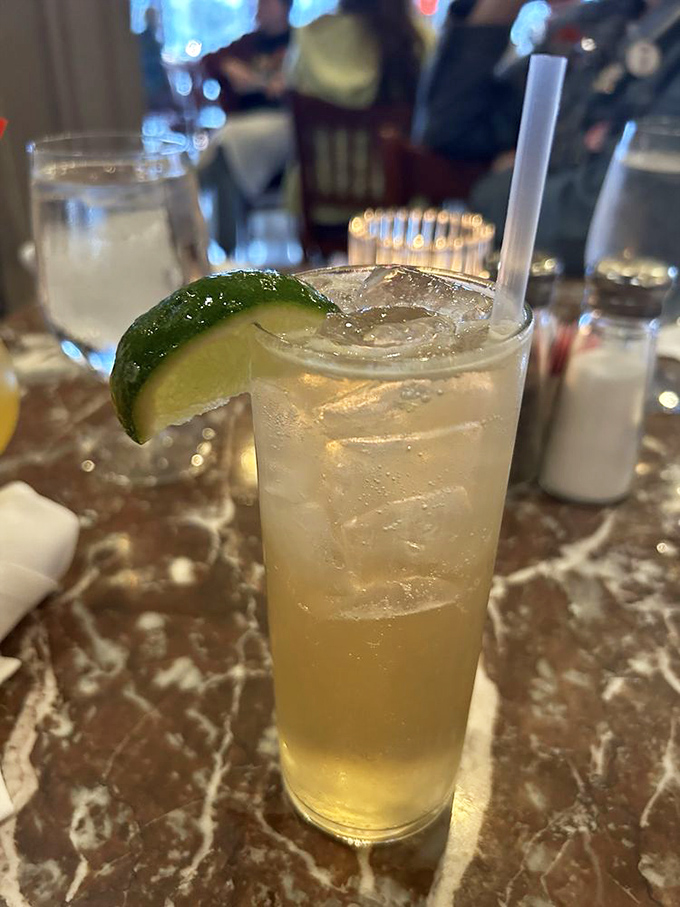 The whiskey drink sits innocently, ice cubes slowly surrendering to gravity, lime perched jauntily like it knows something you don't yet.