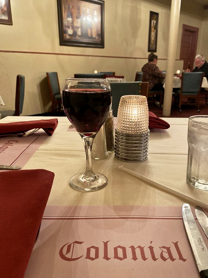 A glass of red, white tablecloths, and that distinctive Colonial logo&mdash;setting the stage for the main event.