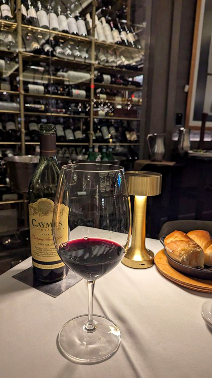 A bottle of Caymus stands sentinel before a wall of possibilities&mdash;because great steak deserves a worthy liquid companion.