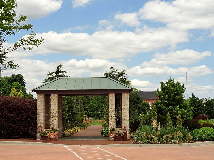 This elegant garden pavilion beckons visitors forward, promising shaded respite and framed views of botanical splendor just beyond its columns.