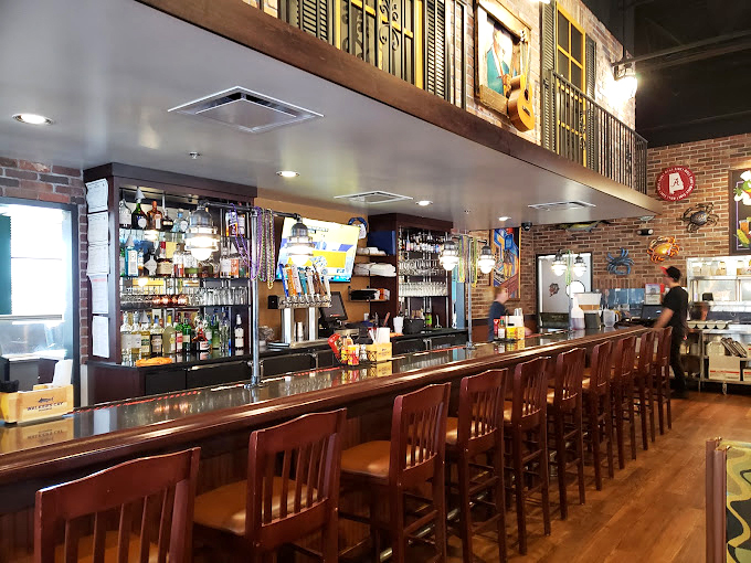 The bar area: where stories flow as freely as the drinks. Those college flags overhead have witnessed countless "you should've tasted it" tales.