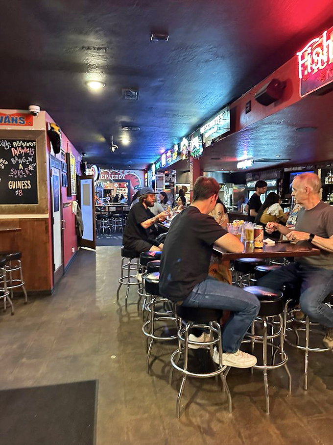 Where strangers become friends over craft beers and burger anticipation. The bar's blue glow promises good times ahead.