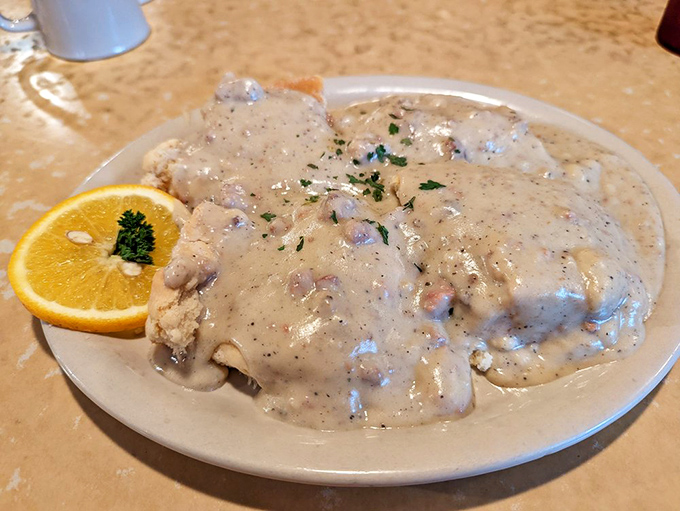 Country gravy cascading over biscuits like a creamy waterfall. This plate doesn't just feed your body—it hugs your soul.