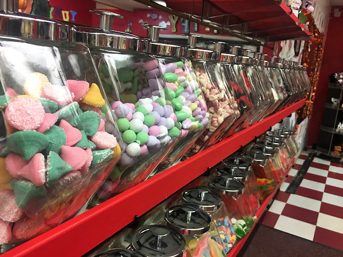 Old-school candy dispensers standing at attention like sweet sentinels. Each turn of the knob delivers childhood memories.