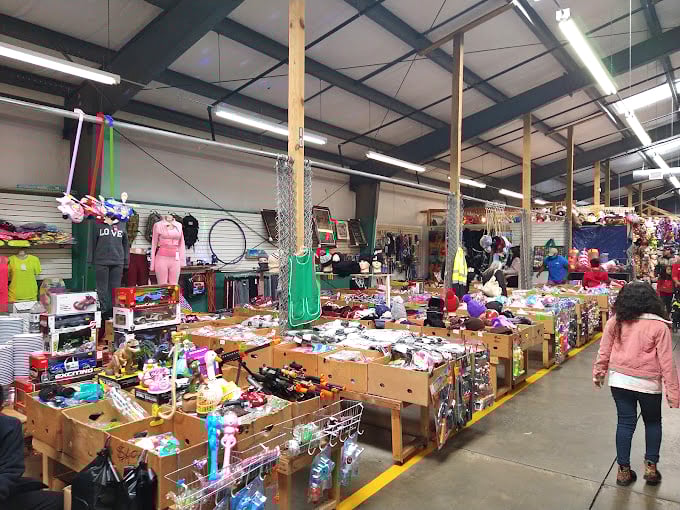 Bargain hunters navigate wooden bins overflowing with potential finds, proving that sometimes life's best treasures require a little digging.