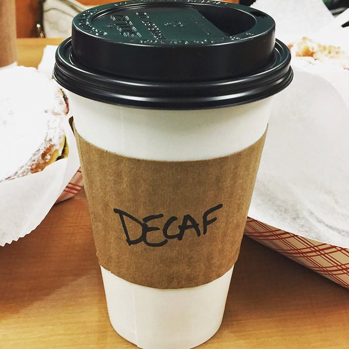 Even the coffee cups have personality here. That "DECAF" scrawl is both informative and slightly judgmental, as all good coffee shop markings should be.