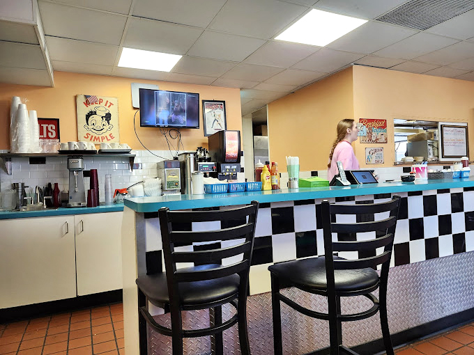 The counter where magic happens. That "Keep It Simple" sign isn't just decoration&mdash;it's the philosophy that's kept Dagwood's thriving since 1938.