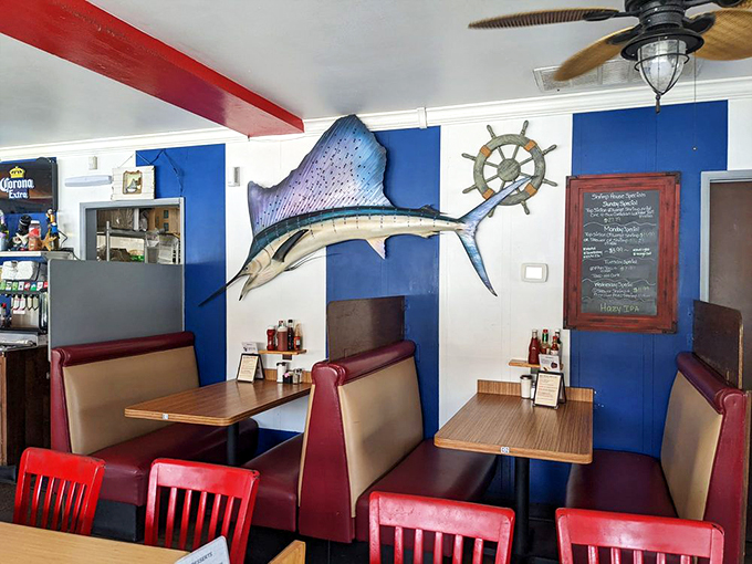 A swordfish mounted on blue walls watches over diners like a maritime guardian angel. The ship's wheel says "trust us, we know our seafood."