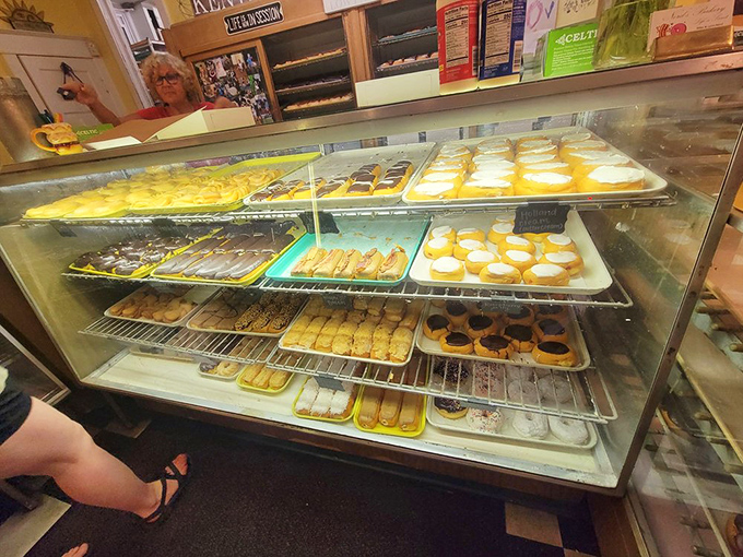 Display cases that could make a diamond jeweler jealous. Each shelf a gallery of edible art, meticulously arranged to maximize your inevitable over-ordering.