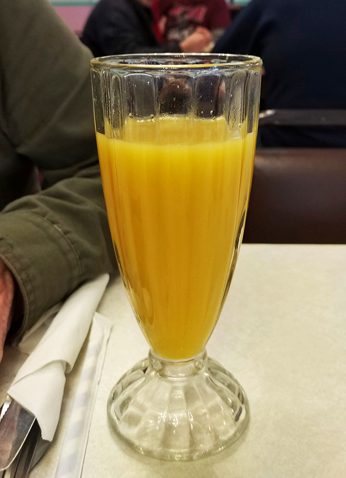 Liquid sunshine in a classic fountain glass. This orange juice isn't just fresh&mdash;it's the morning optimism you can actually drink.
