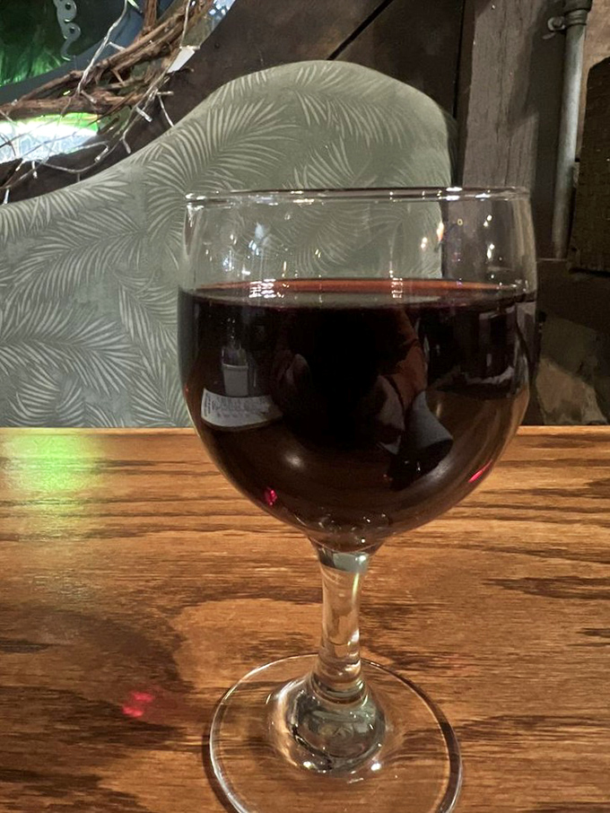 Even the wine looks at home in this rustic setting, catching the light like a ruby jewel against the honest wooden tabletop.