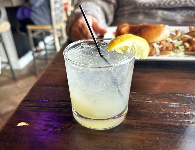 This isn't just a cocktail—it's liquid sunshine with a lemon twist, sitting pretty on a wooden table like it's waiting for its Instagram moment.