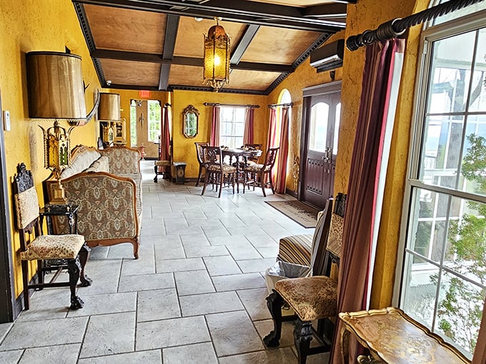 Sunlight streams through tall windows in this elegantly appointed sitting room, where golden walls and rich textiles invite visitors to relax in royal comfort.