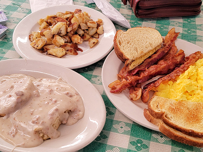 The holy trinity of breakfast: crispy potatoes, savory gravy, and a plate of eggs and bacon that means business.