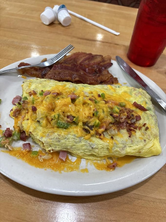 This omelet contains more fillings than my last tax return, yet somehow maintains its structural integrity. Engineering marvel meets breakfast classic.
