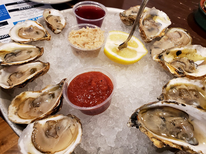 A dozen glistening oysters on ice—nature's perfect appetizer. Each one a tiny ocean in a shell, waiting for a squeeze of lemon.