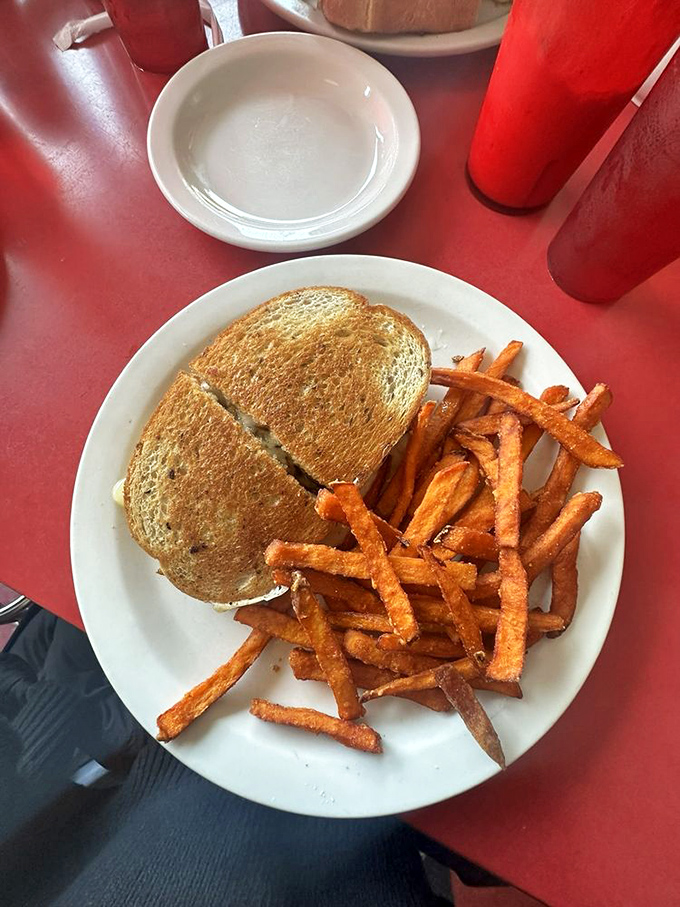 The patty melt—comfort food's ambassador—paired with sweet potato fries that look like they were hand-cut by someone who truly understands what makes life worth living.