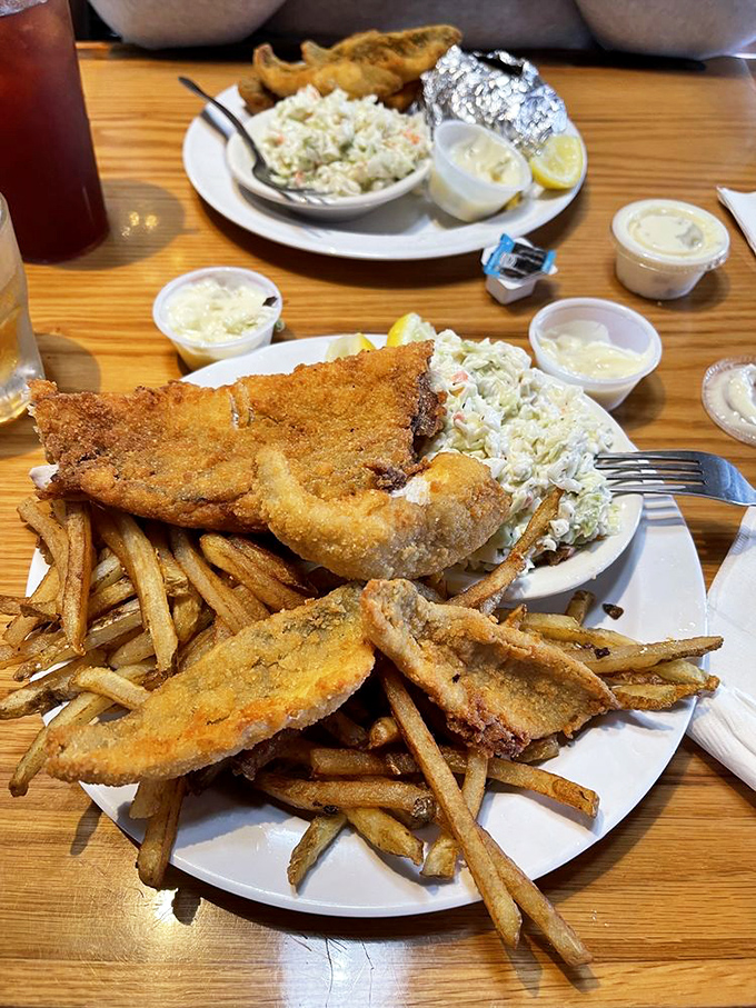The perch and walleye combo plate: where Lake Erie's finest swimmers come to rest on a bed of golden fries with coleslaw as their pillow.