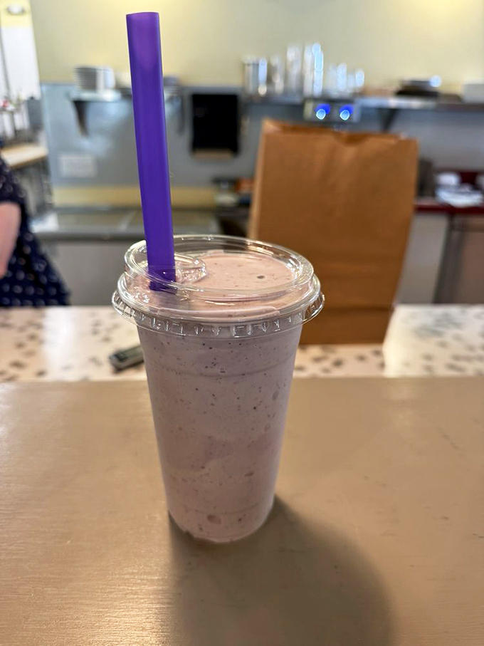 This isn't just a milkshake; it's a portable happiness delivery system with a purple straw standing tall like a victory flag.