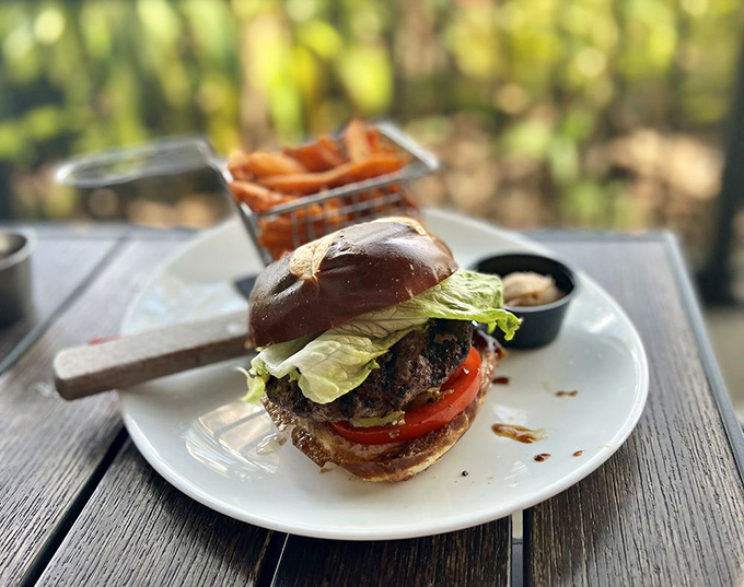 This burger on a rustic wooden table tells a story of craftsmanship&mdash;both in its construction and in the hands that created it.