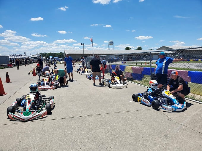 The colorful helmets against green grass create a racetrack ballet. Each driver calculating how to explain later why they "let" their kids win.