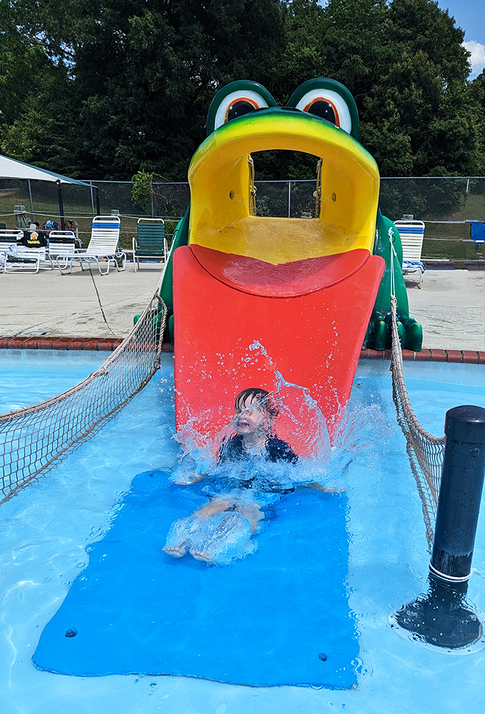 The frog slide: where childhood dreams and physics meet in perfect harmony. That splash landing is pure summer poetry in motion.