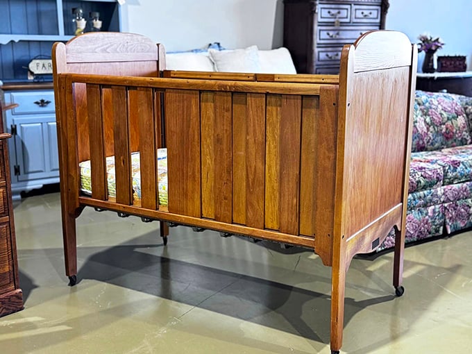 A wooden crib with the patina of generations stands ready for its next chapter, surrounded by furniture that's seen more family dinners than most restaurants.