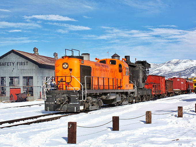 Ely: "The Nevada Northern Railway's vibrant orange locomotive cuts through winter's blanket, a moving museum that doesn't just display history&mdash;it powers through it."
