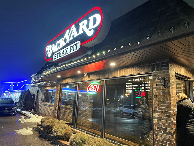 Night lights, grilling heights! The Backyard's glowing sign is like a beacon for beef lovers seeking flame-kissed perfection in Gurnee.