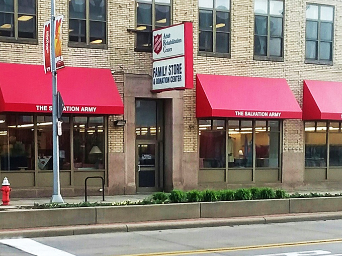 The Salvation Army's red awnings pop against the historic brick building like exclamation points in the sentence "Look at these amazing deals!"