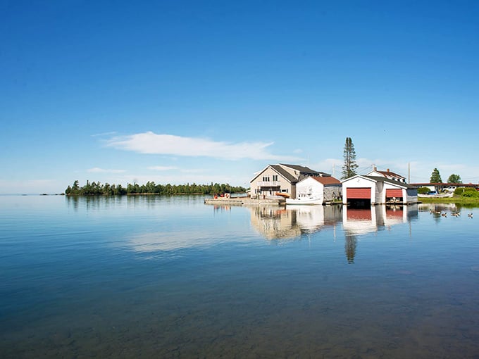 Crystal-clear waters mirror the buildings along Copper Harbor's peaceful shoreline. Social media filters not required for this perfect scene.