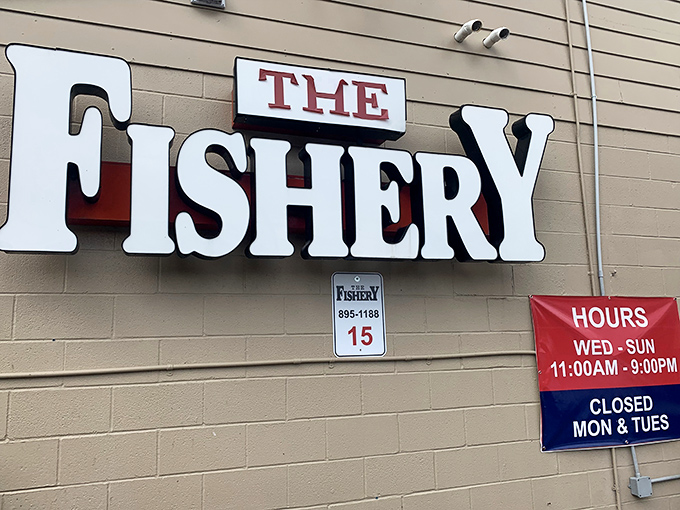 The Fishery's vintage sign with two fishermen tells you everything: simple, authentic, and catching great seafood for generations.