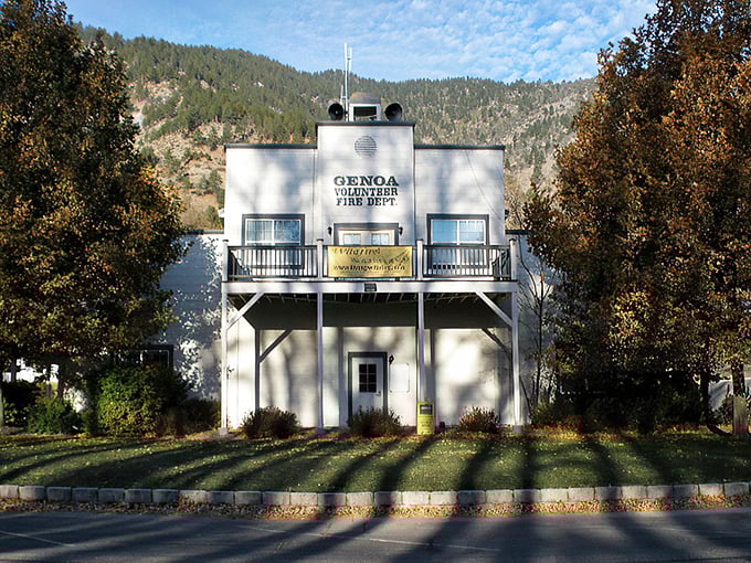 The modest white firehouse stands ready against the mountains, a reassuring presence that has protected generations of Genoa residents.
