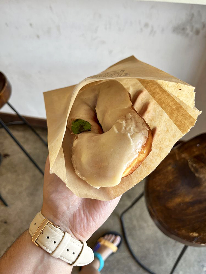 Like sunrise captured in donut form, this peachy-pink confection wears its glaze with the confidence of something that knows it's irresistible.