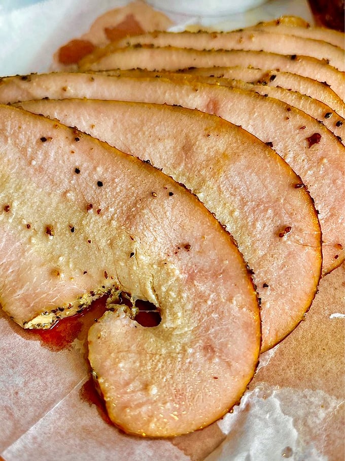 Turkey so moist it defies poultry physics. These delicate pink slices prove that in skilled hands, even the humble turkey can achieve barbecue greatness.