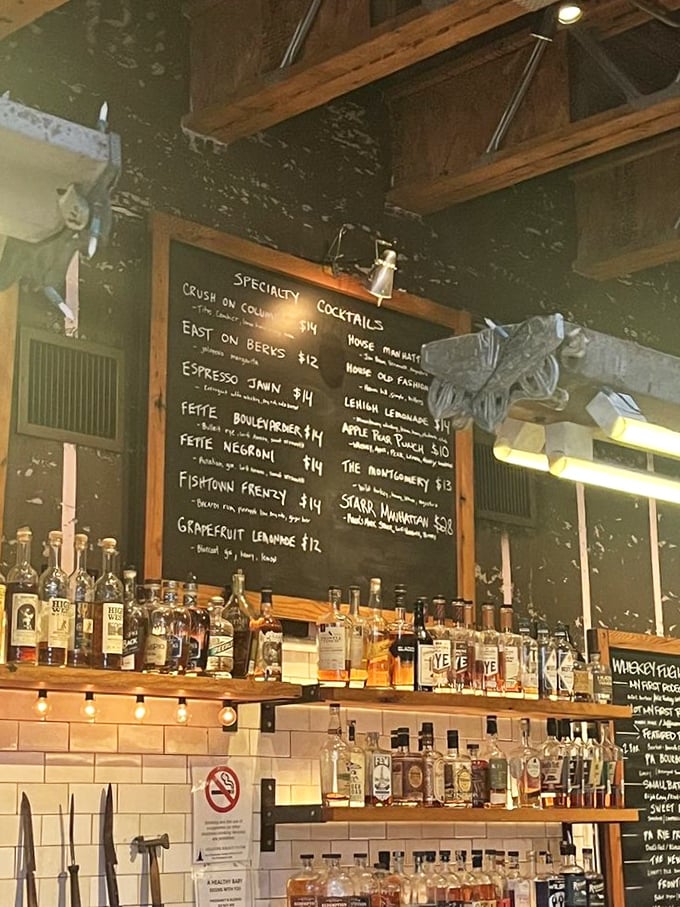 The chalkboard cocktail menu promises liquid adventures. "Fishtown Frenzy" sounds less like a drink and more like what happens after you have three.