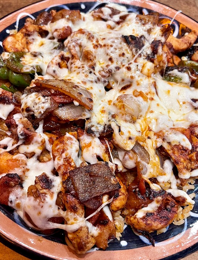 This isn't just chicken and rice &ndash; it's Arroz con Pollo that would make your abuela nod in approval, smothered in melted cheese that stretches with each forkful.