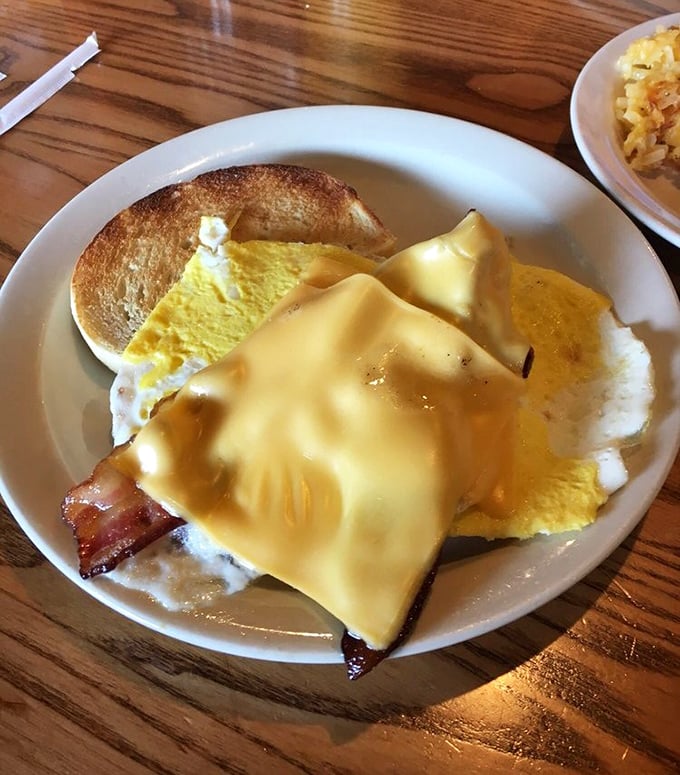 Breakfast sandwich architecture at its finest. Melty cheese cascading over eggs and bacon&mdash;a morning masterpiece on toasted bread.