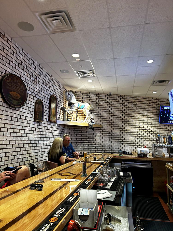 The bar area offers a front-row seat to Rehoboth Beach's favorite pizza show, where brick walls and wooden counters set the stage for culinary magic.