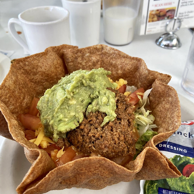 A tostada shell transformed into an edible bowl of possibilities. The guacamole crown makes this dish royalty in the Tex-Mex universe.
