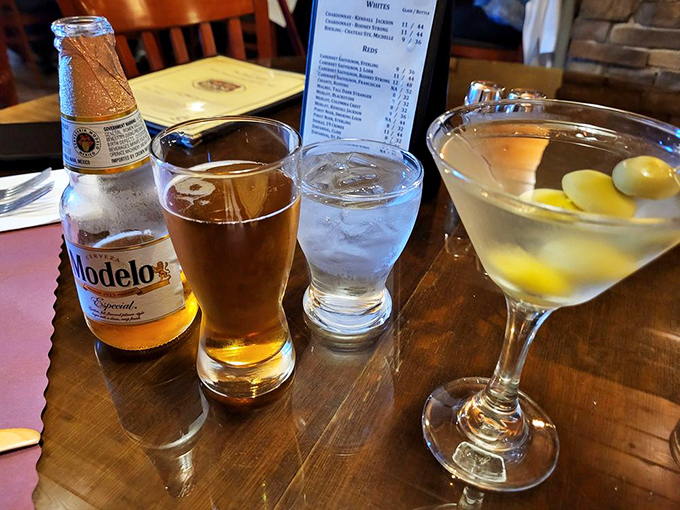 The holy trinity of dining pleasure – cold beer, clear water, and a perfectly crafted martini waiting to complement your meal.