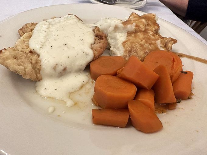This breaded pork tenderloin sandwich with its crispy edges deserves its own zip code, served with perfectly cooked vegetables and gravy.