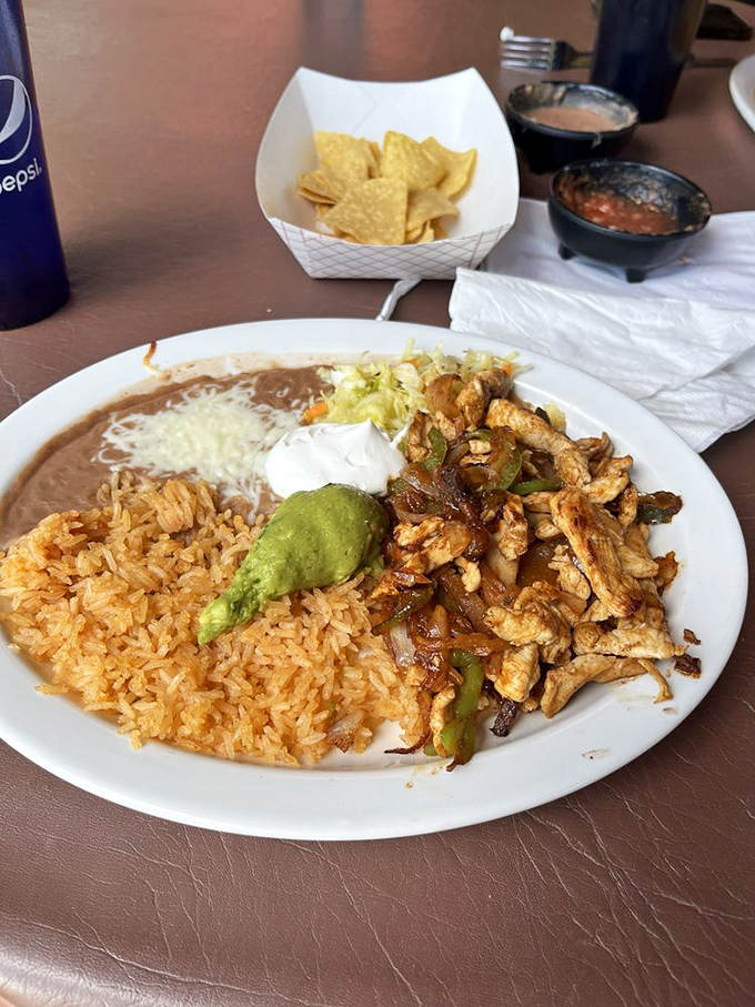 Sizzling fajitas that announce their arrival before you see them, with perfectly grilled chicken, peppers, and onions ready for their tortilla blankets.
