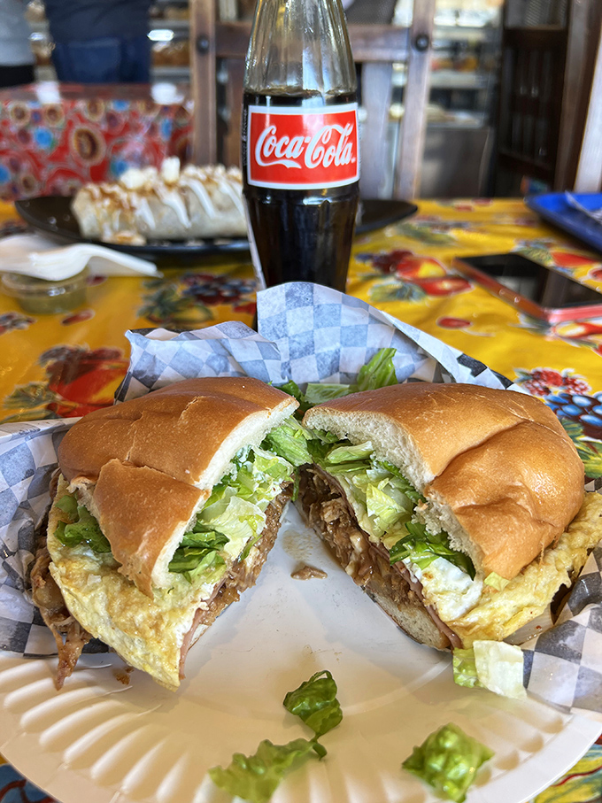 This isn't just a sandwich; it's architectural perfection. Layers of savory goodness between perfectly toasted bread, with that ice-cold Mexican Coke standing by for backup.