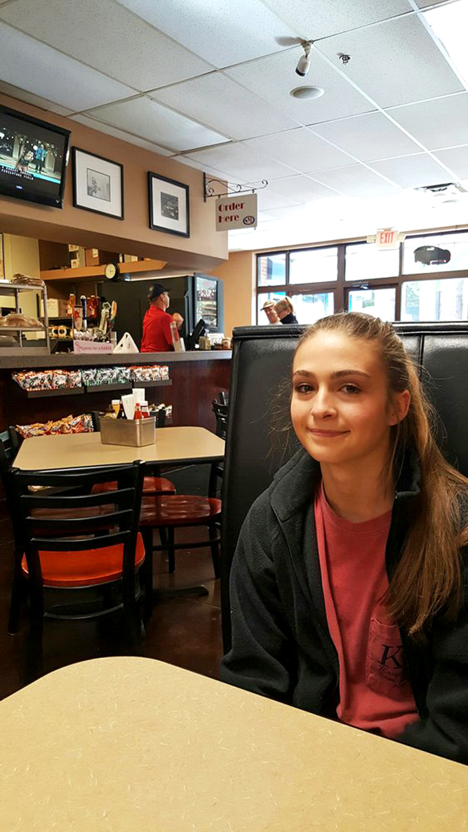 The diner experience in full swing&mdash;"Order Here" sign pointing the way to happiness while framed New York memories watch from the walls.